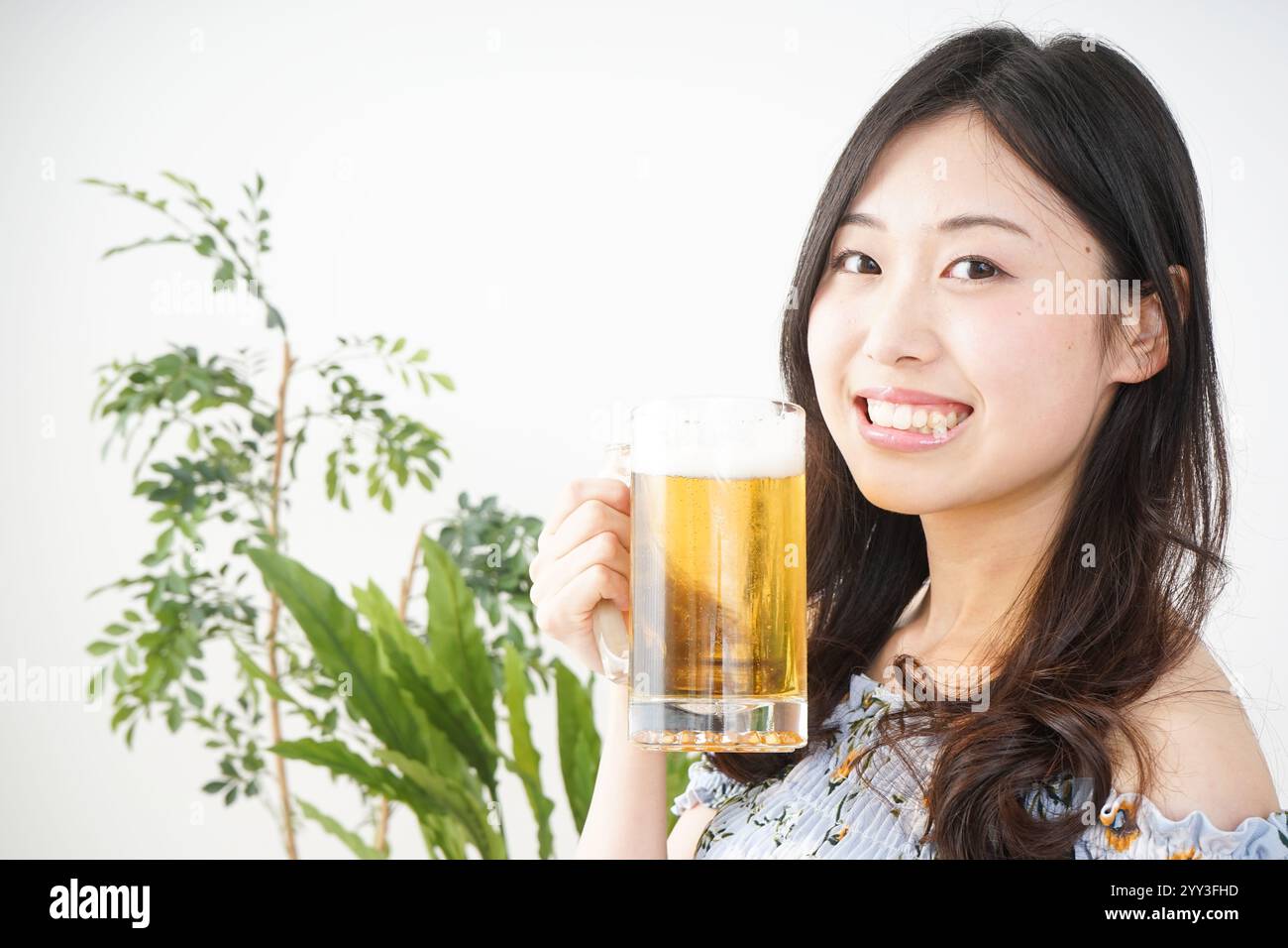 Young woman drinking beer in room Stock Photo - Alamy