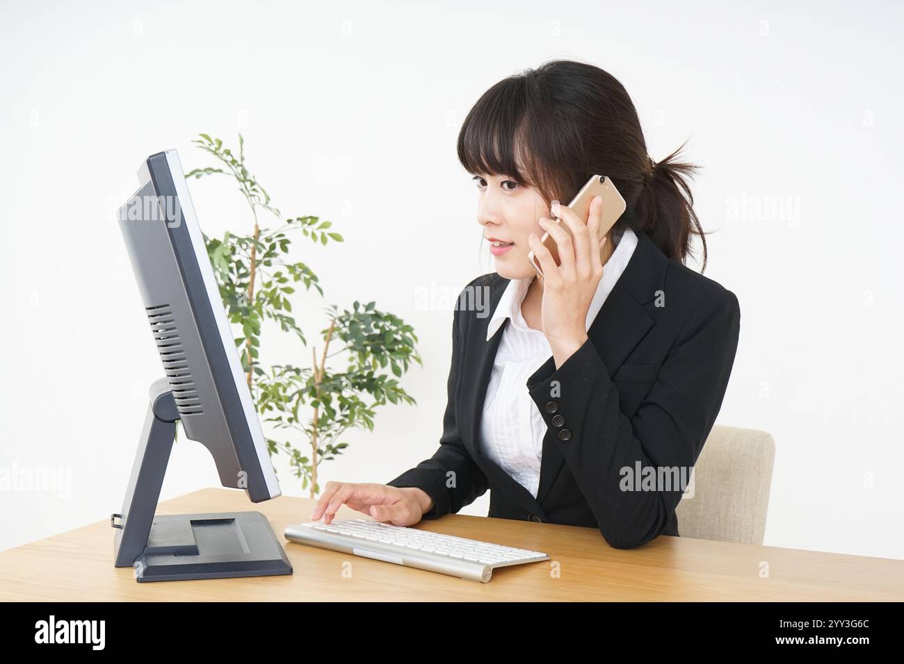 Businesswoman working at a desk in an office Stock Photo - Alamy