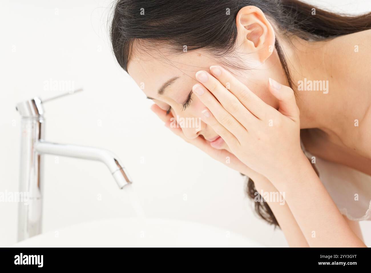 Young women washing their face Stock Photo - Alamy