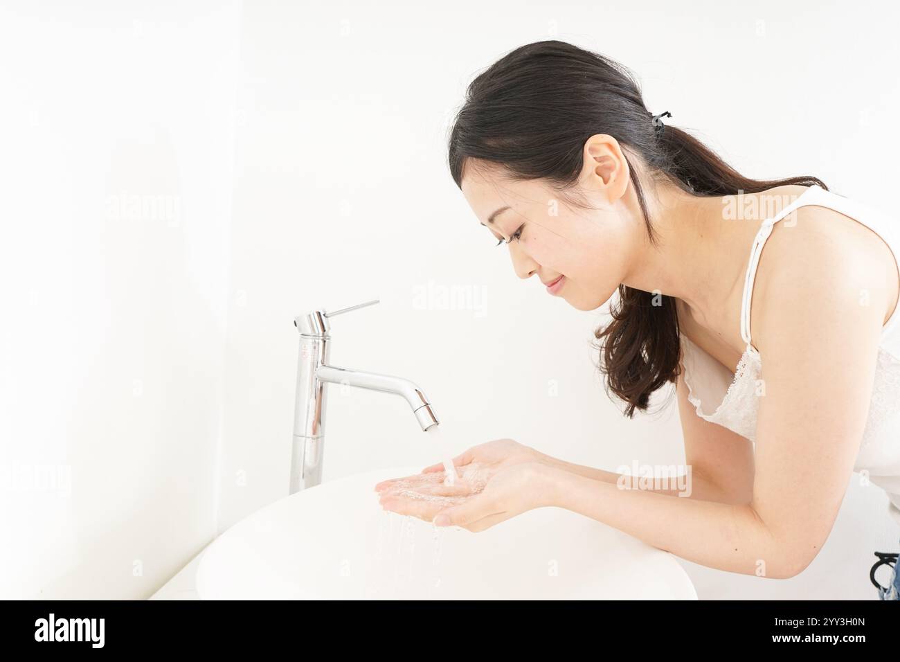 Young women washing their face Stock Photo - Alamy