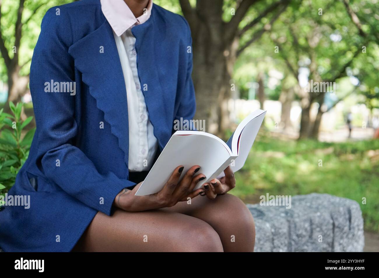 Black woman reading in park Stock Photo - Alamy