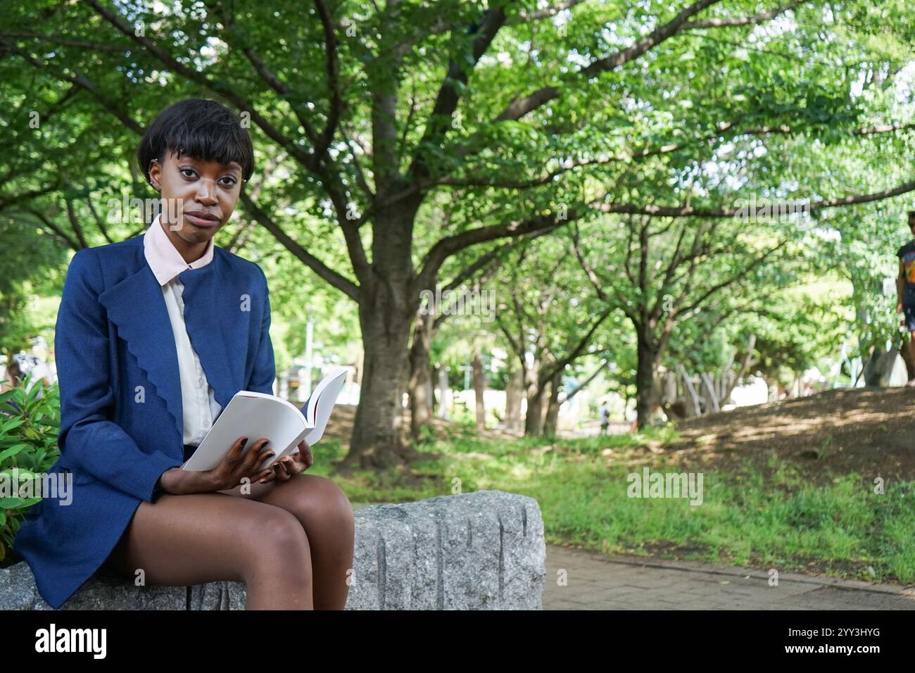 Black woman reading in park Stock Photo - Alamy