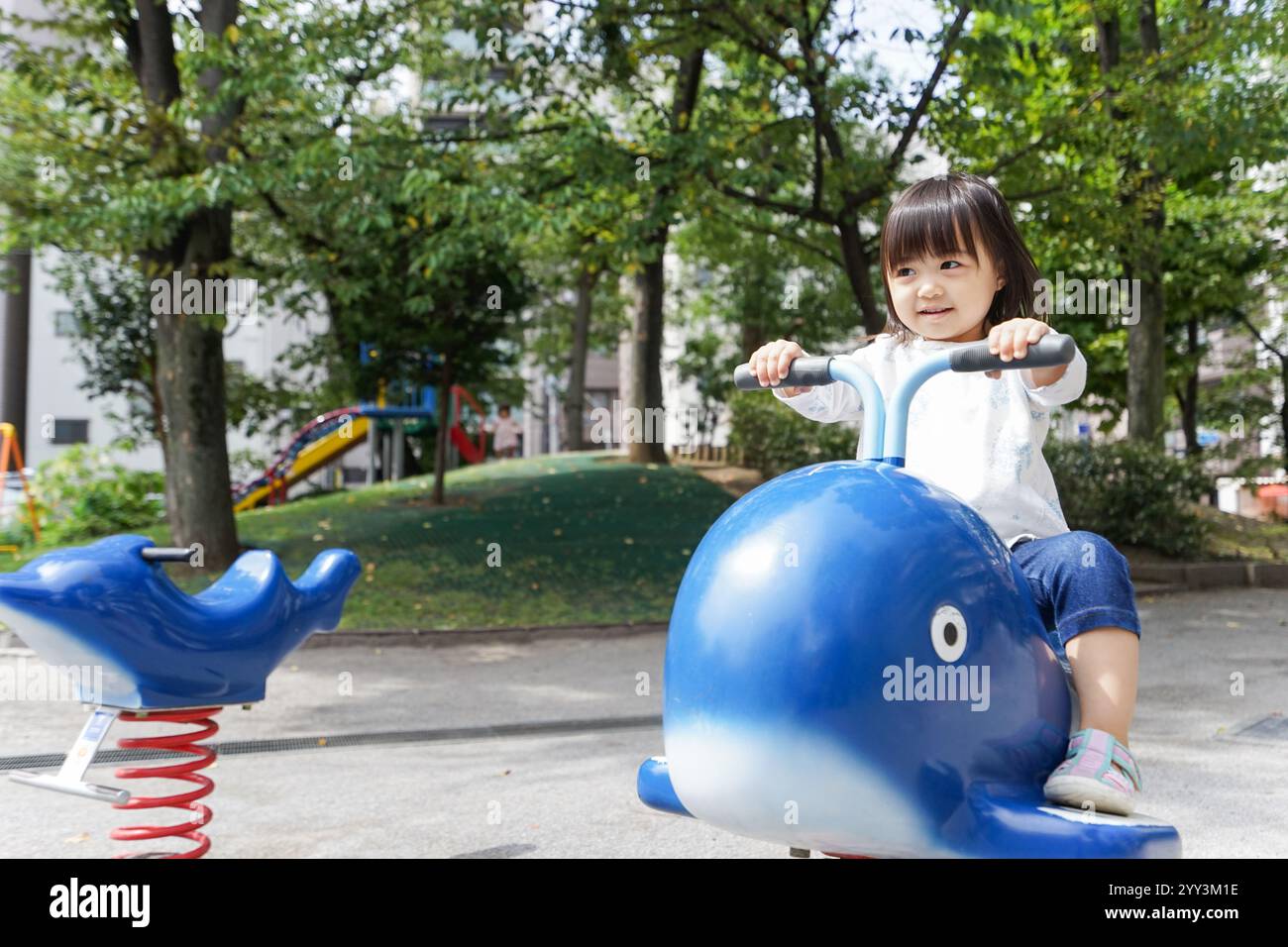 Child playing alone in park Stock Photo - Alamy