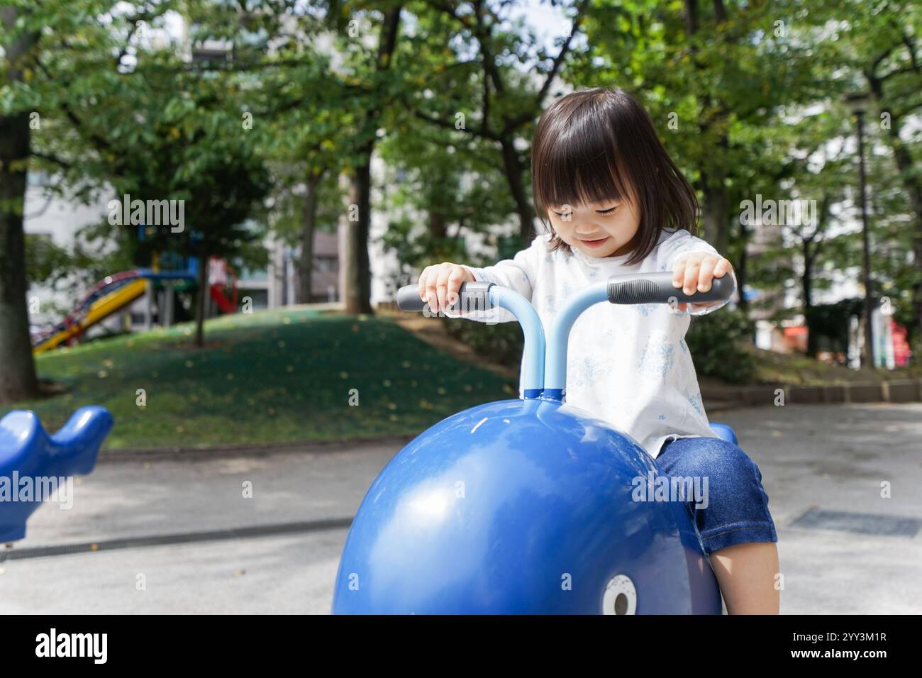 Child playing alone in park Stock Photo - Alamy