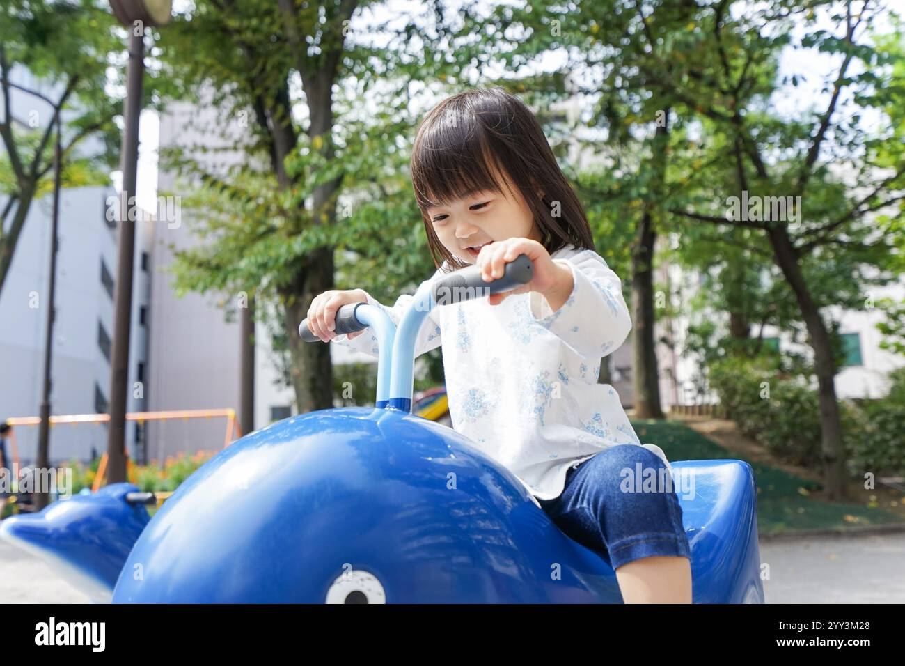 Child playing alone in park Stock Photo - Alamy