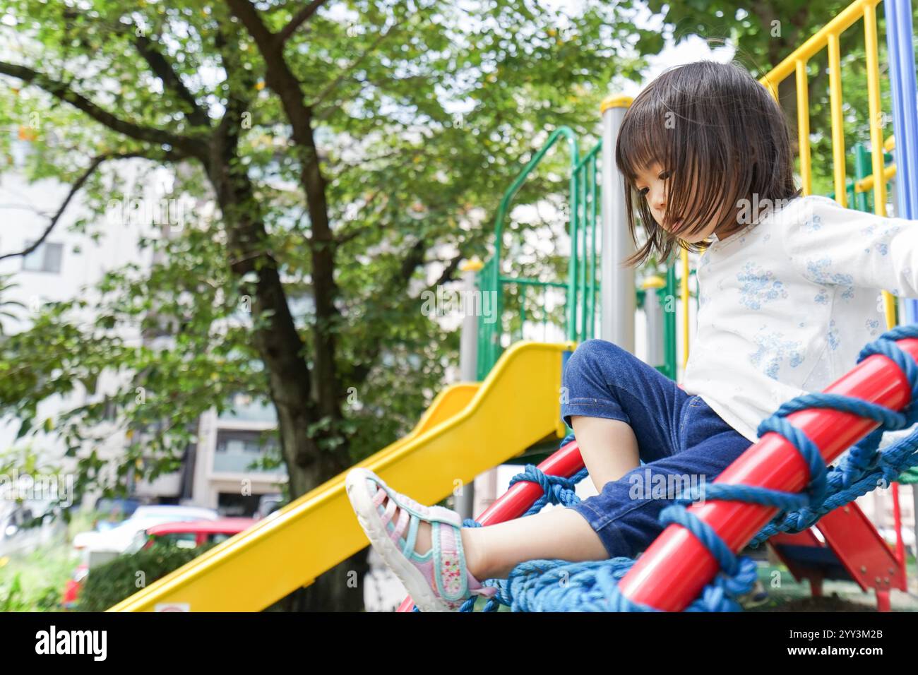 Child playing alone in park Stock Photo - Alamy