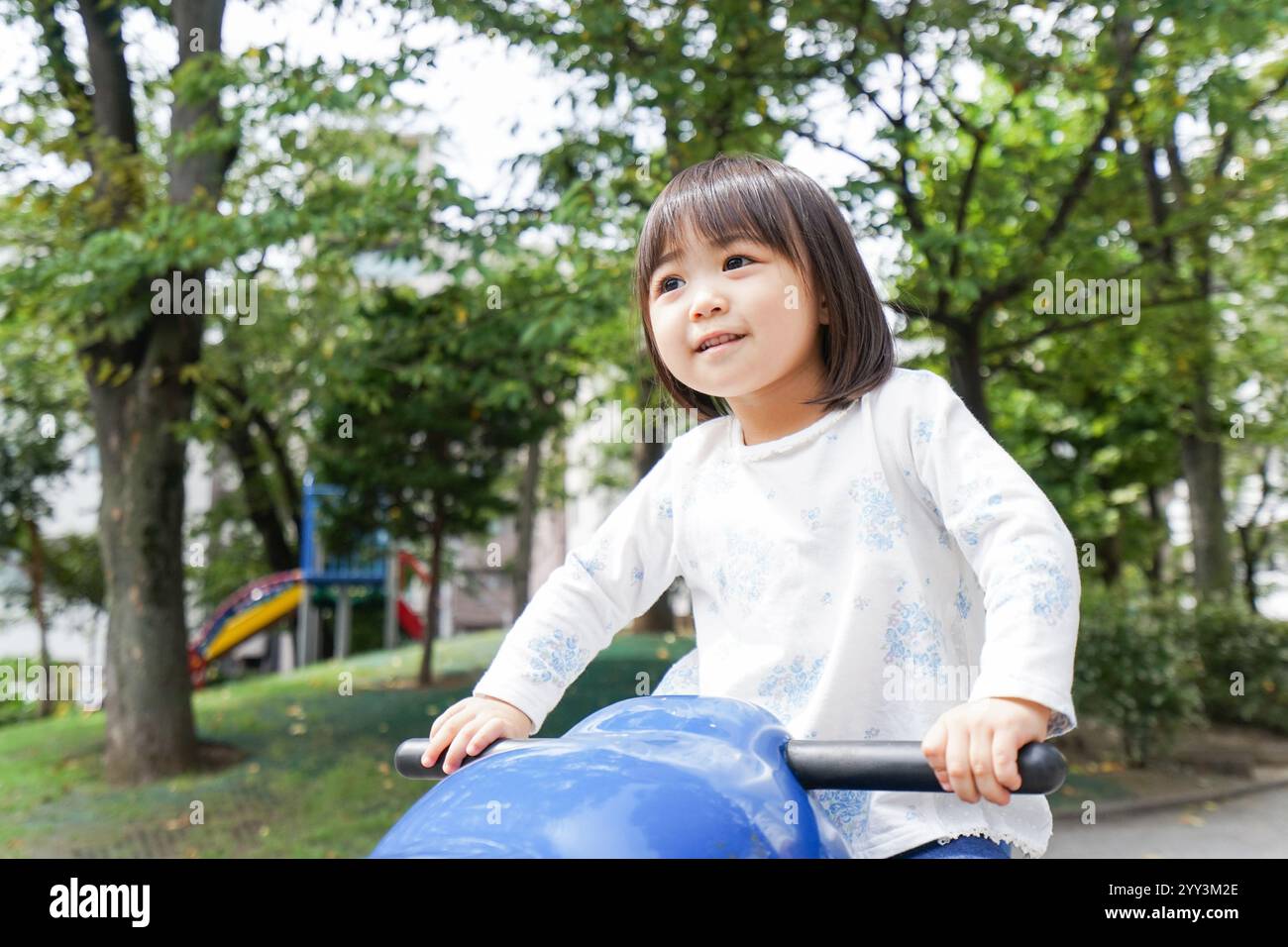 Child playing alone in park Stock Photo - Alamy