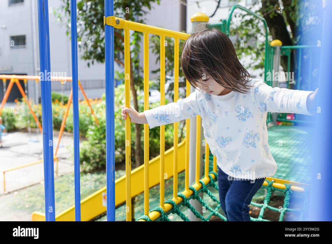 Child playing alone in park Stock Photo - Alamy