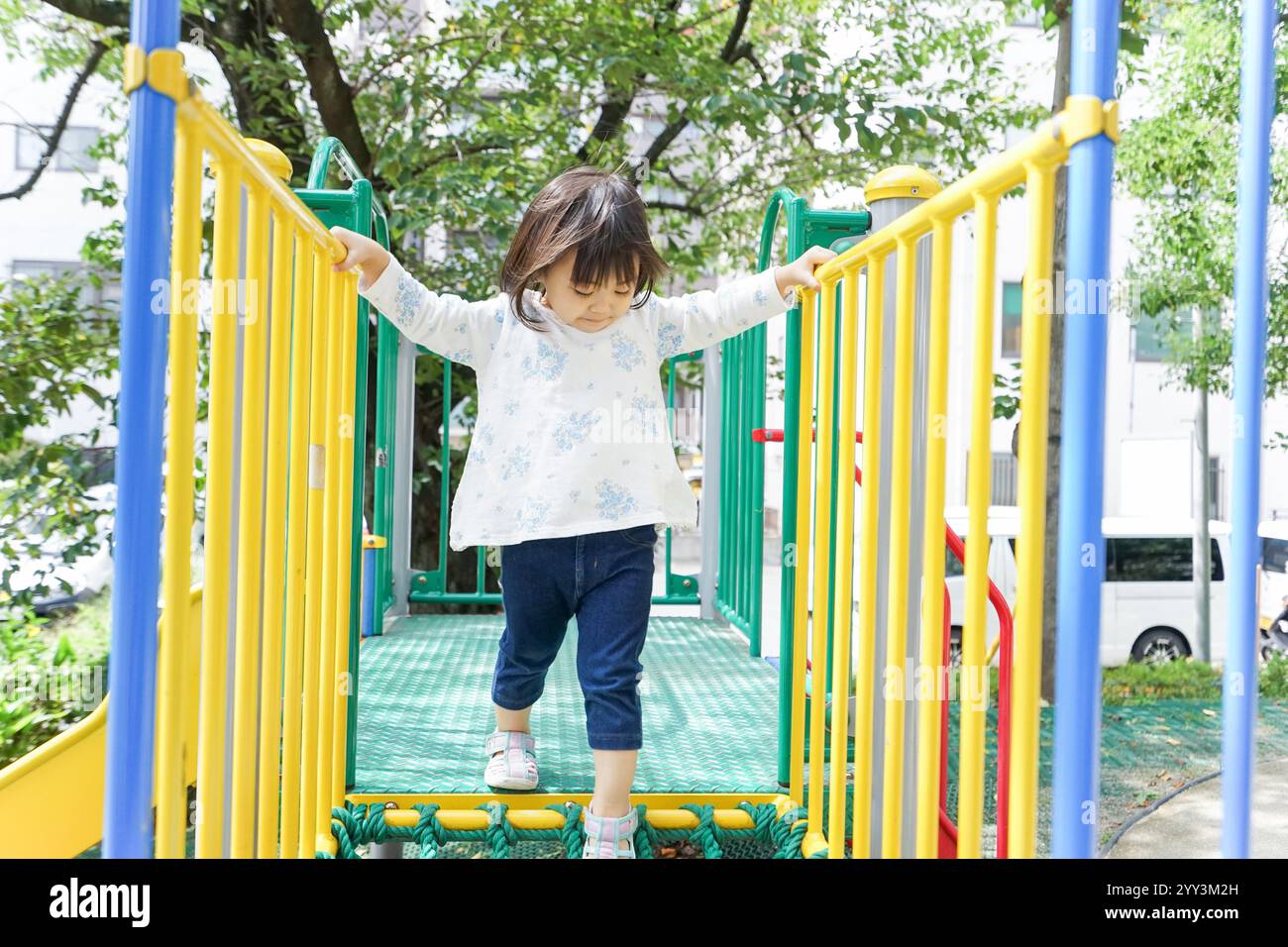 Child playing alone in park Stock Photo - Alamy