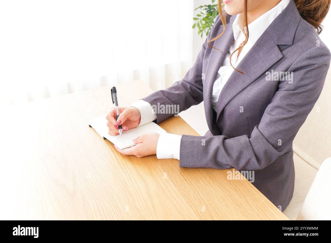 Business woman taking notes Stock Photo - Alamy
