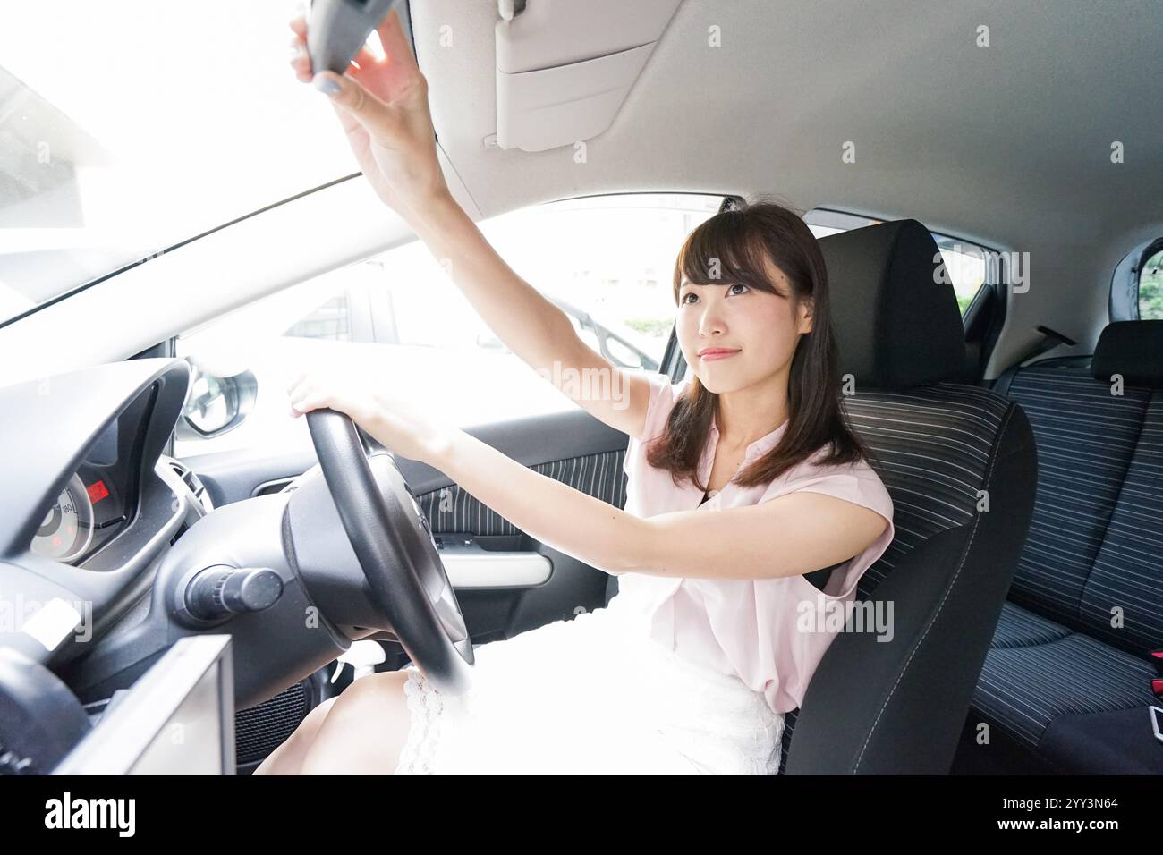 Driver checking for safety in rear-view mirror Stock Photo - Alamy