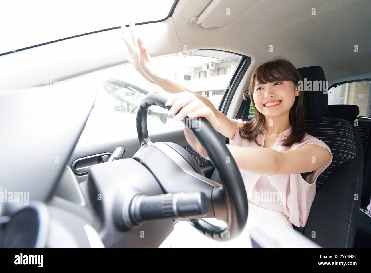 Waving female driver Stock Photo - Alamy