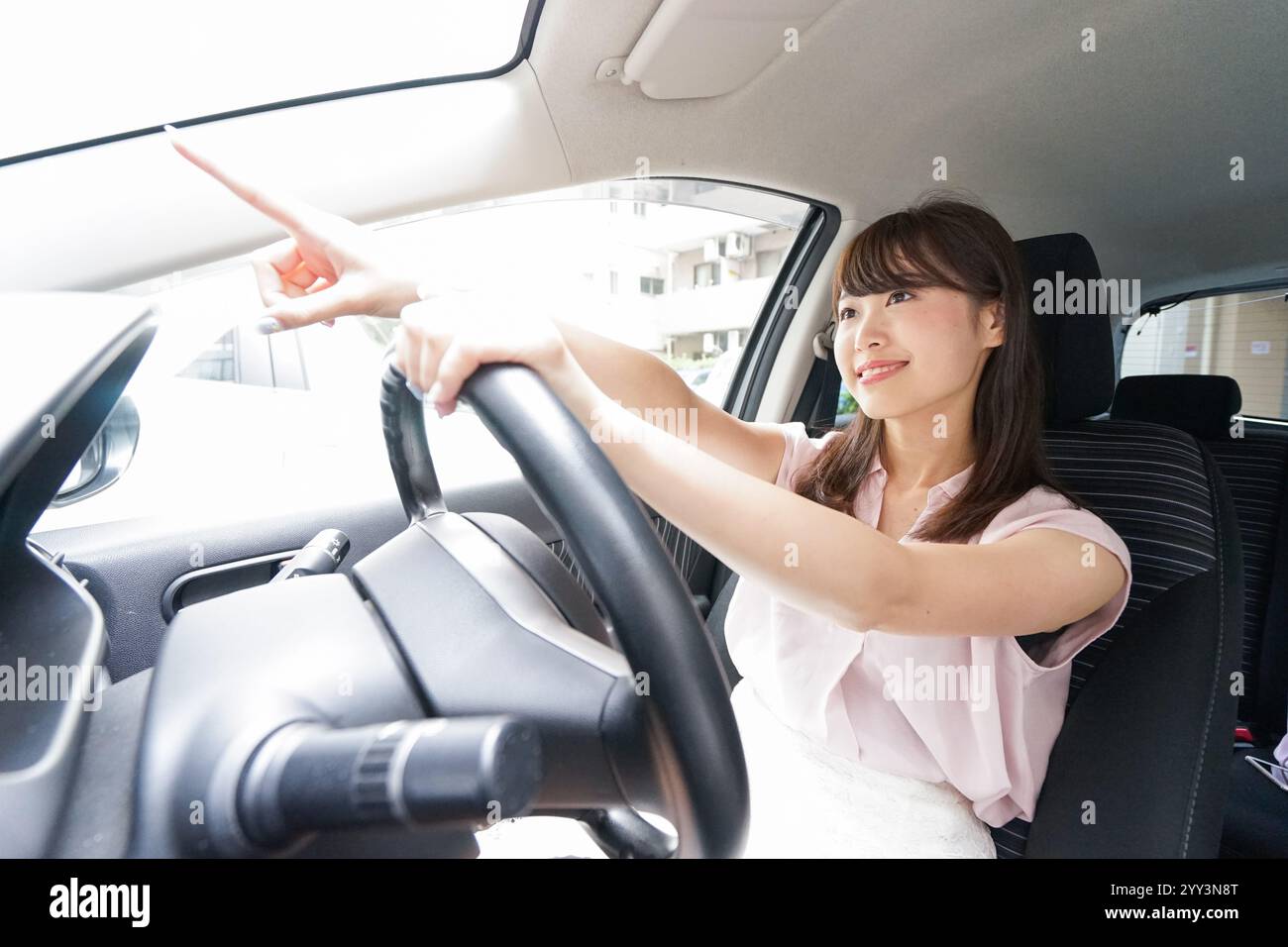 Female driver pointing finger Stock Photo - Alamy