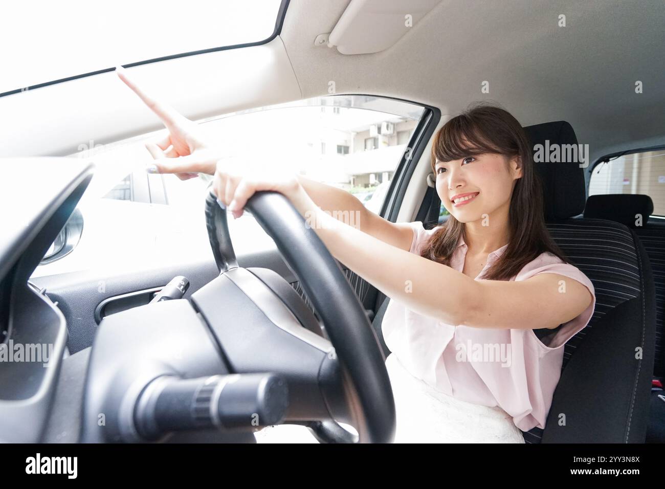 Female driver pointing finger Stock Photo - Alamy