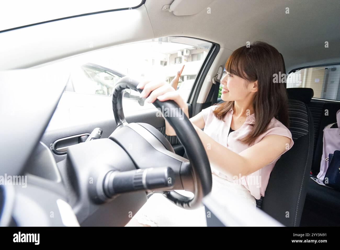 Waving female driver Stock Photo - Alamy