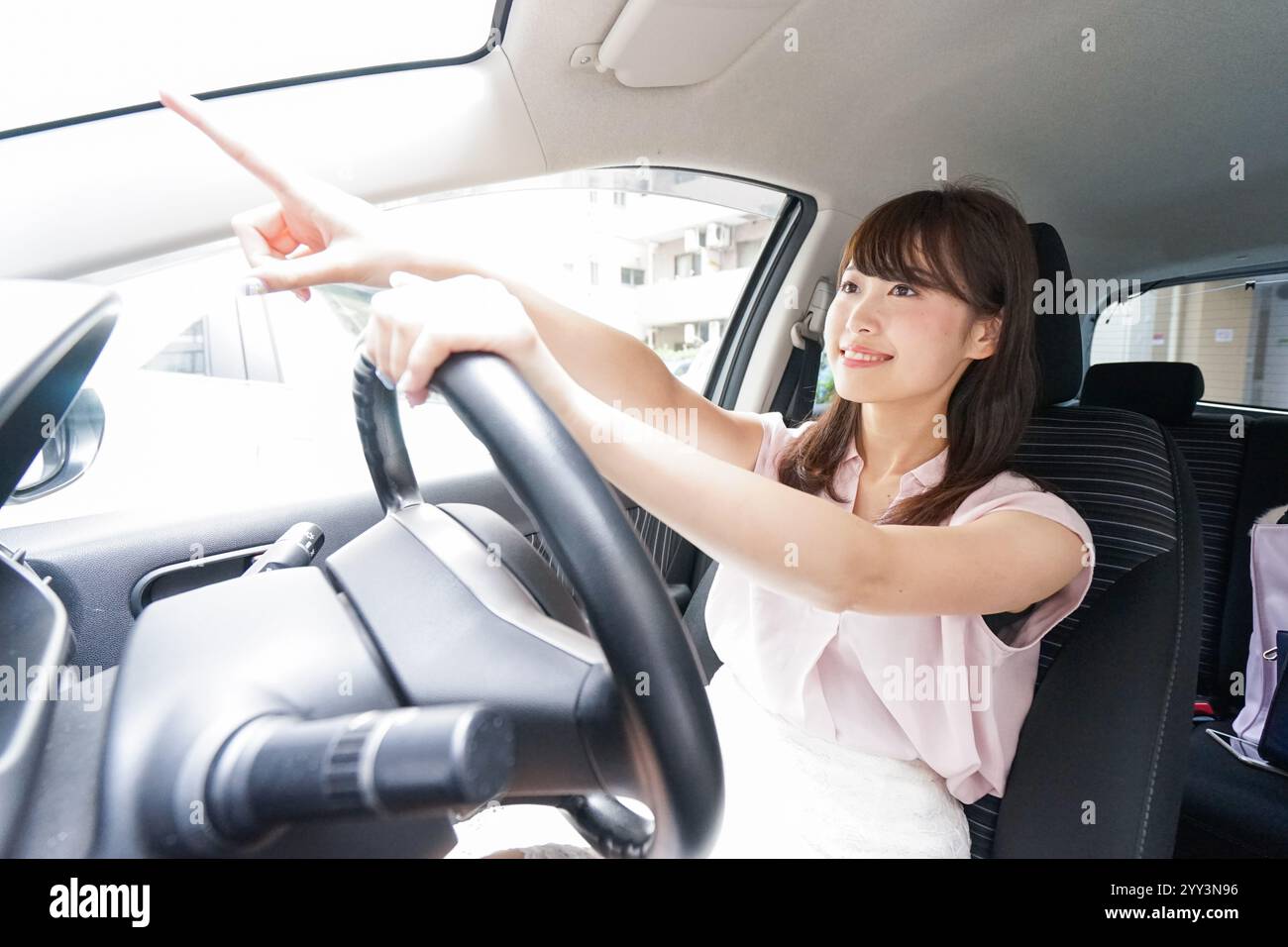 Female driver pointing finger Stock Photo - Alamy