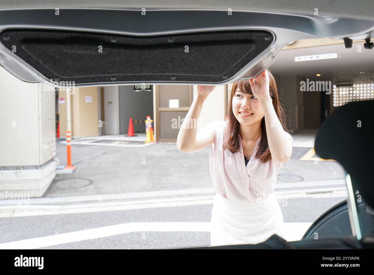 Woman opening car boot Stock Photo - Alamy