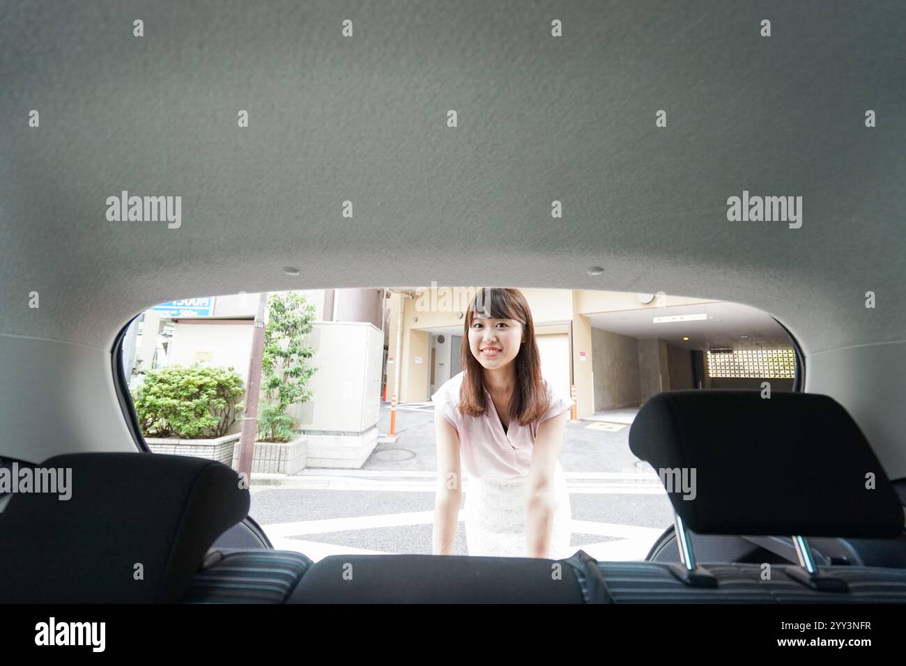 Woman opening car boot Stock Photo - Alamy