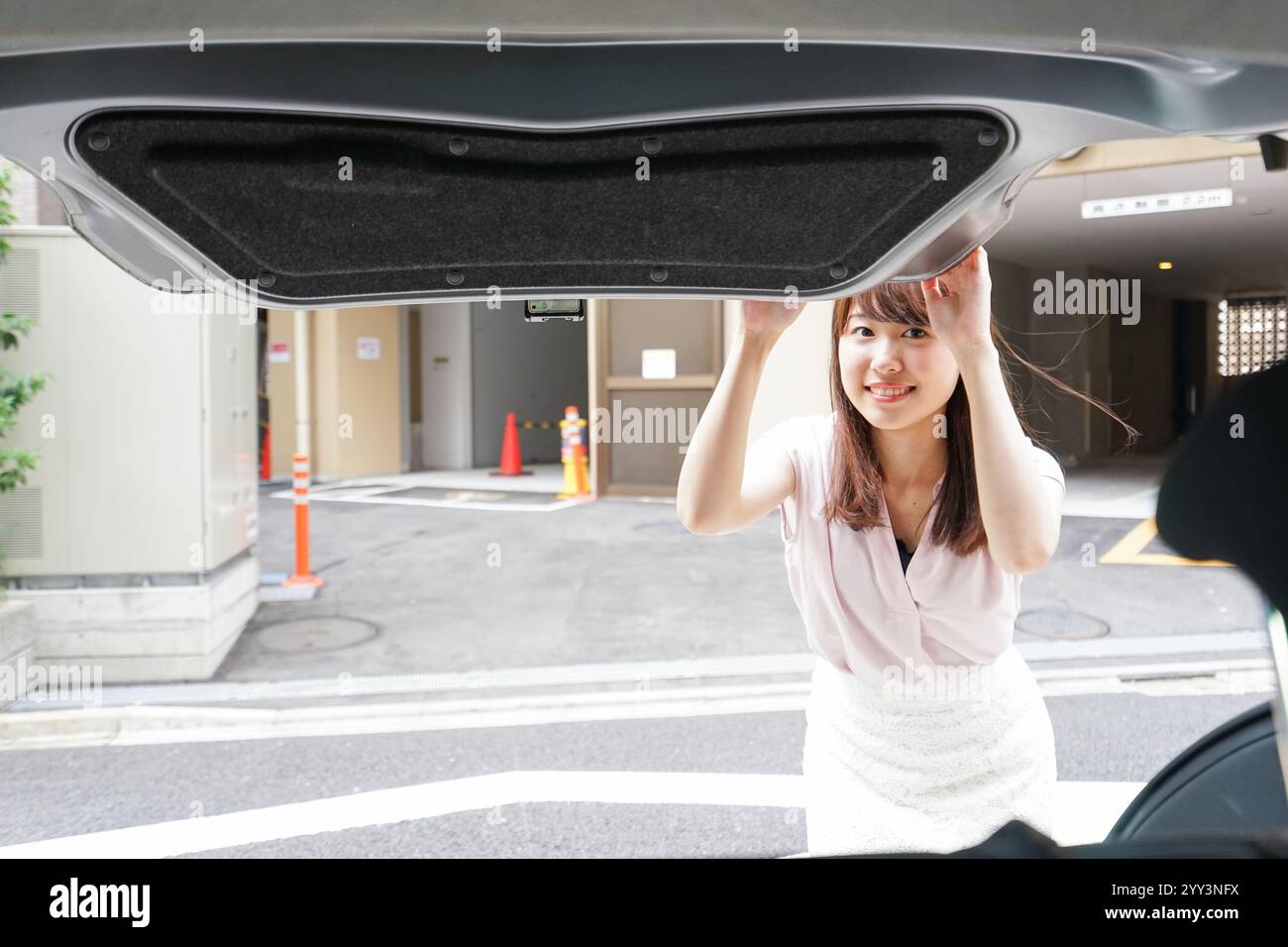 Woman opening car boot Stock Photo - Alamy