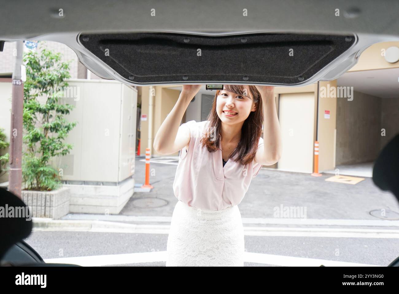 Woman opening car boot Stock Photo - Alamy