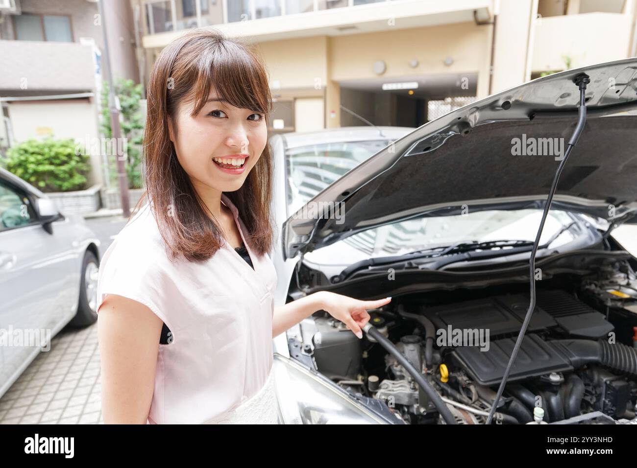 Woman performing car maintenance Stock Photo - Alamy