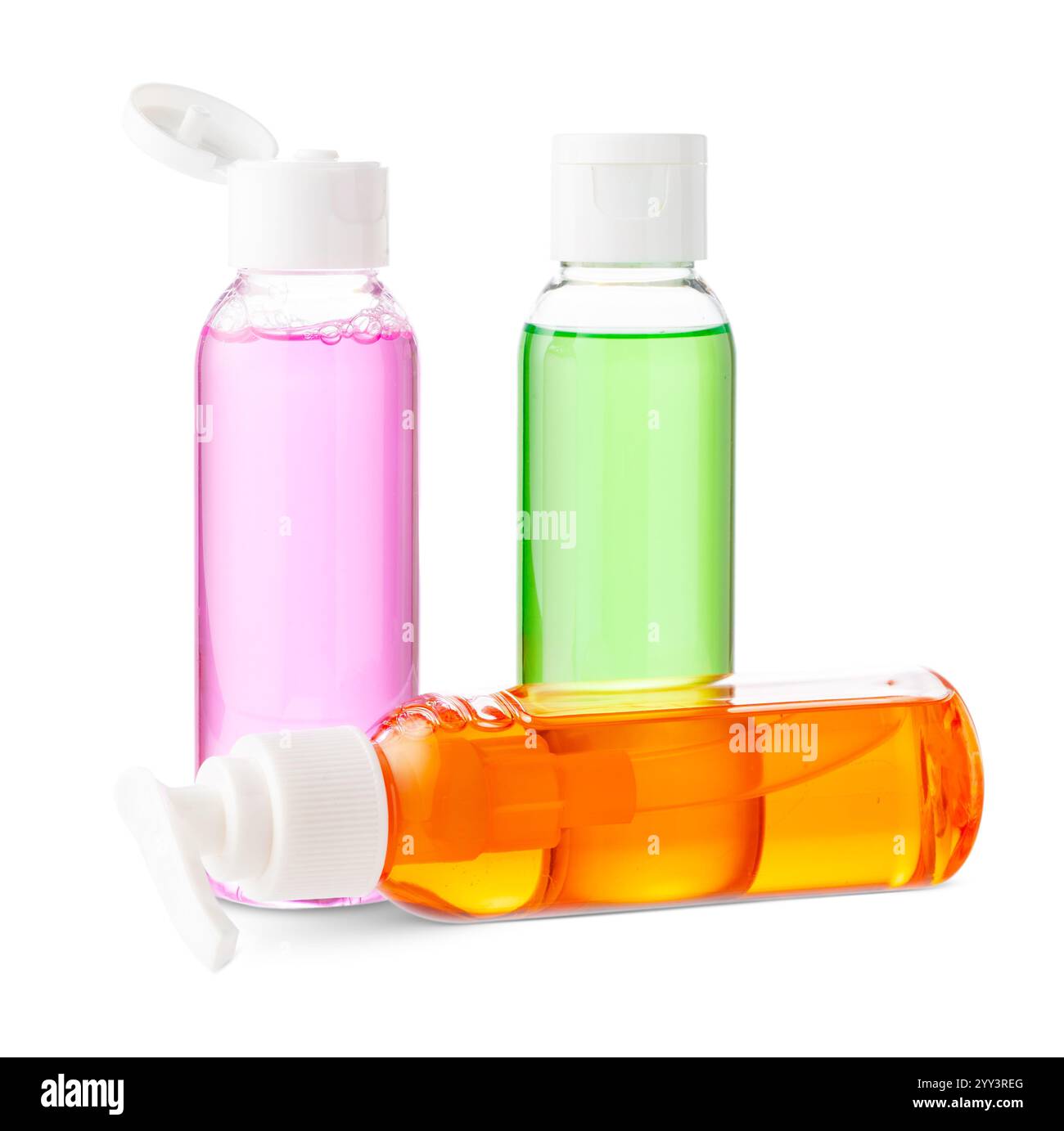 Various bottles with colored liquids and pumps arranged on white ...