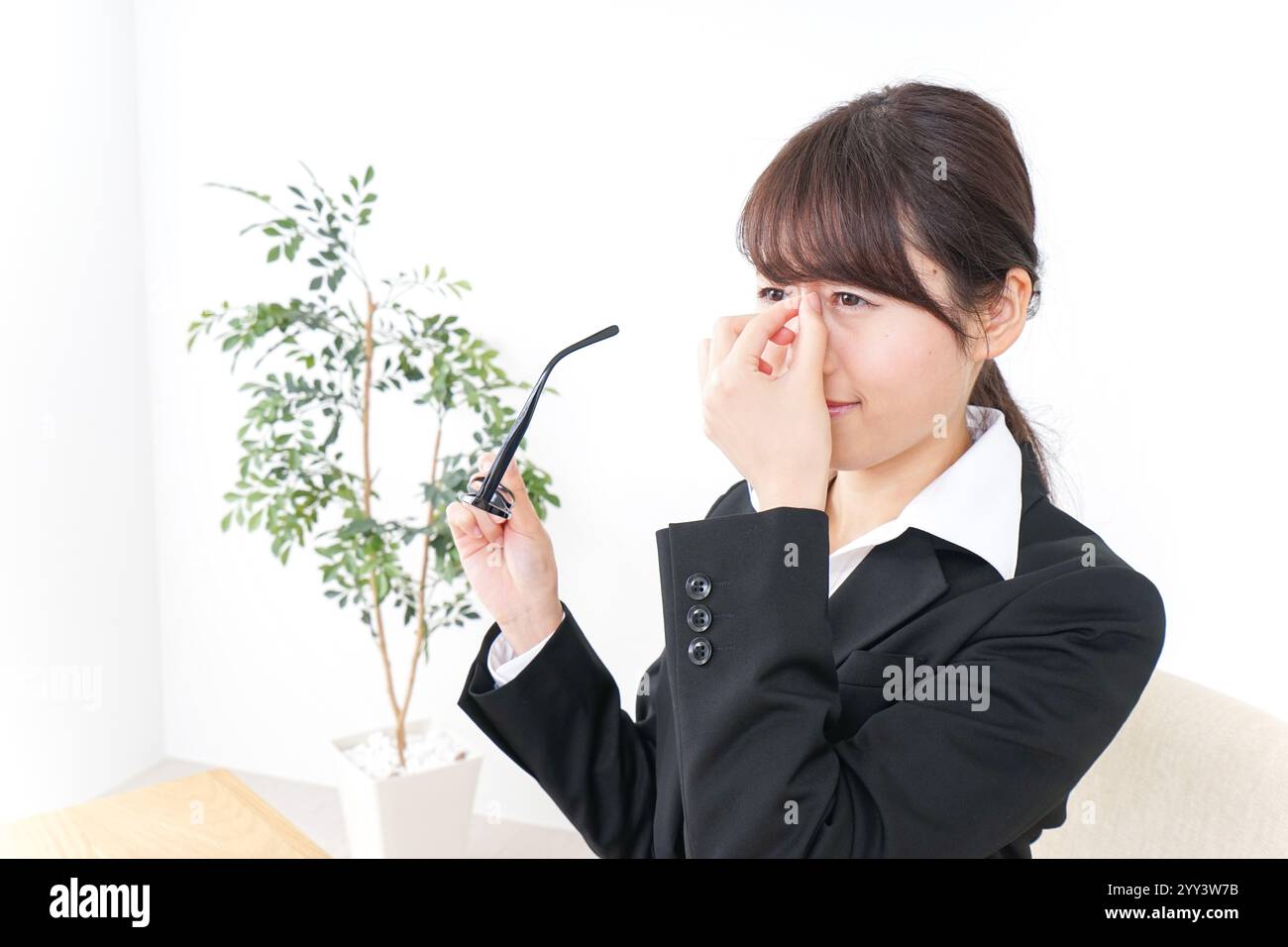 Businesswoman suffering from dry eye fatigue Stock Photo - Alamy