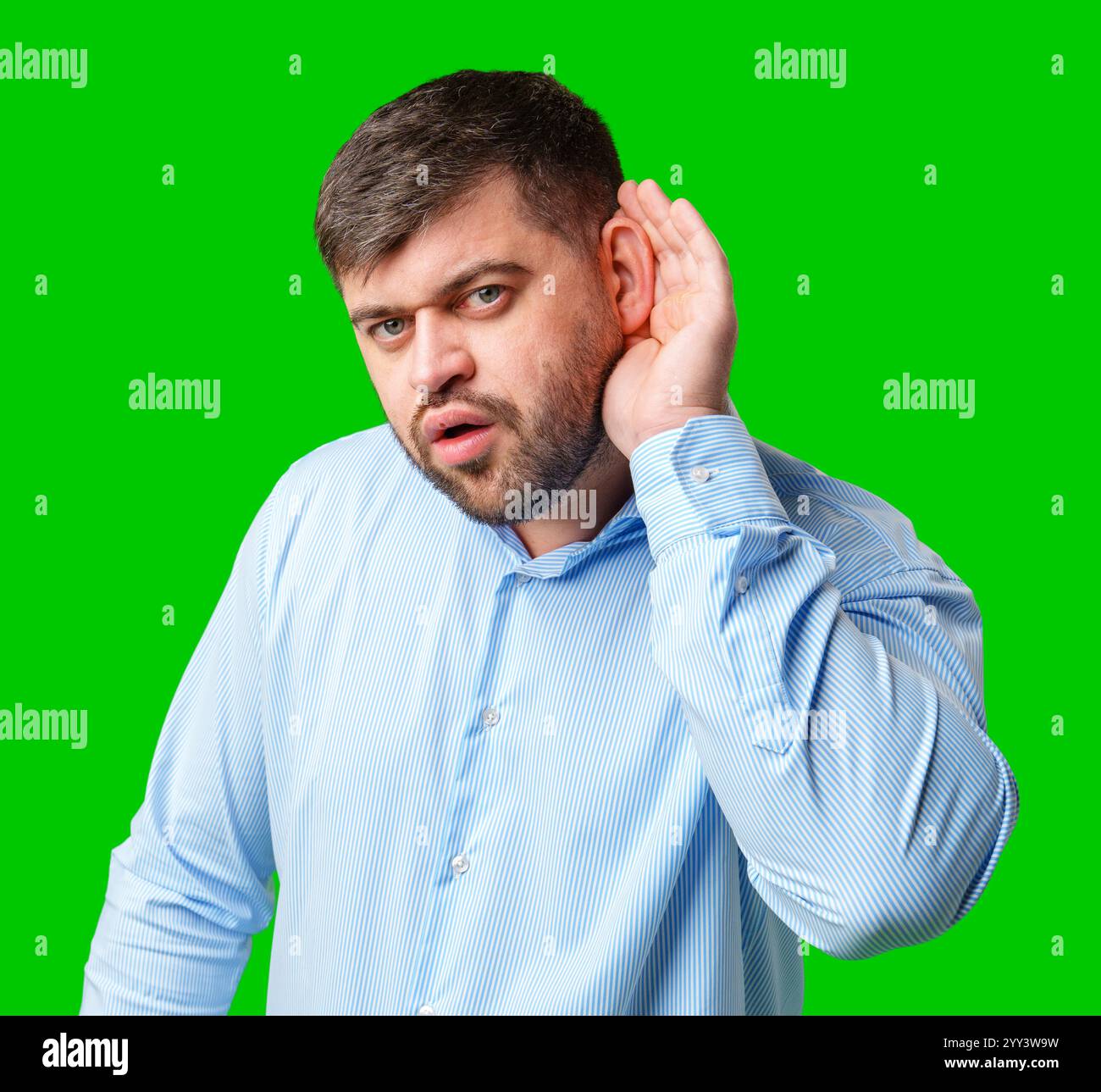 A man listening intently with a surprised expression in a bright green ...