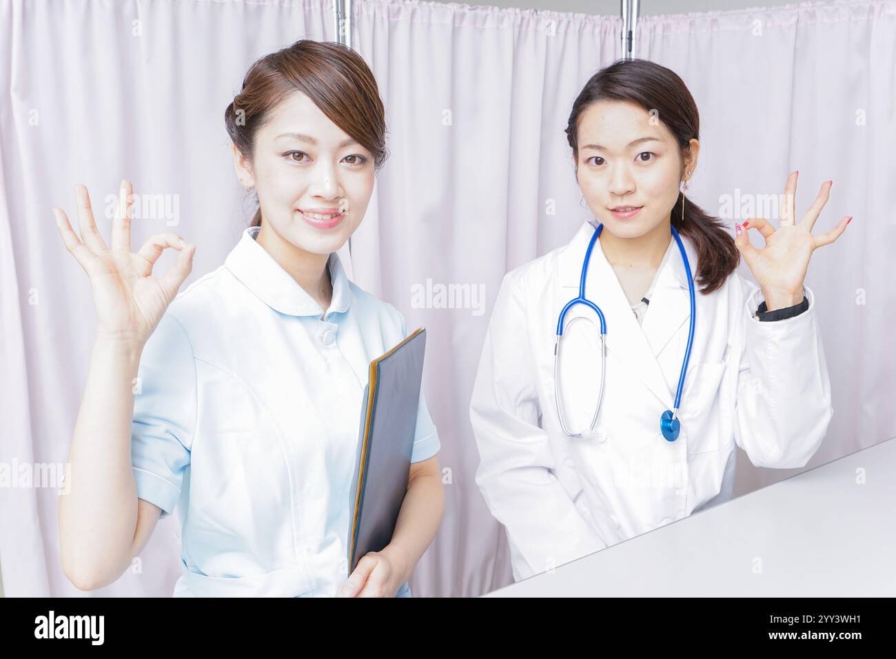 Doctor and nurse signing OK Stock Photo - Alamy