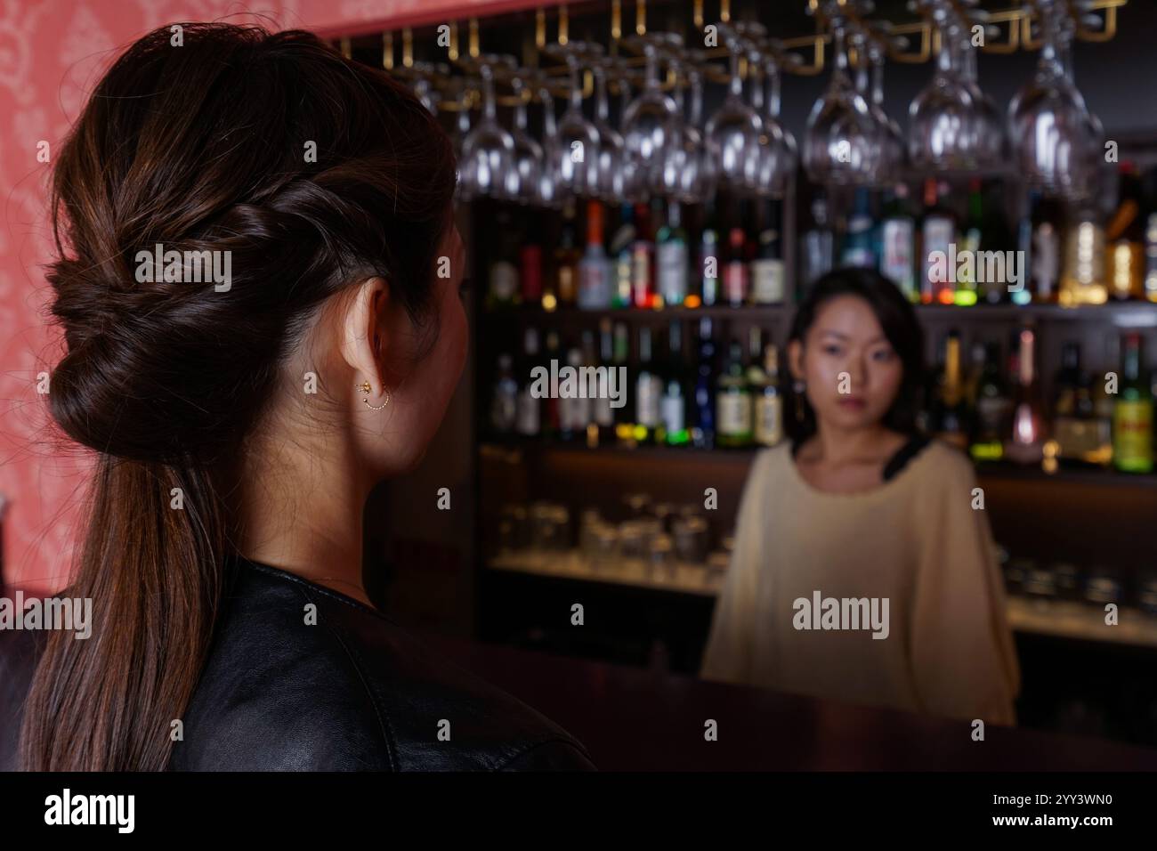 Woman sitting at bar counter Stock Photo - Alamy