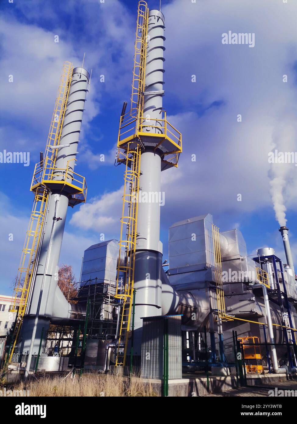 A large factory with thick smoke billowing out from its tall chimneys ...