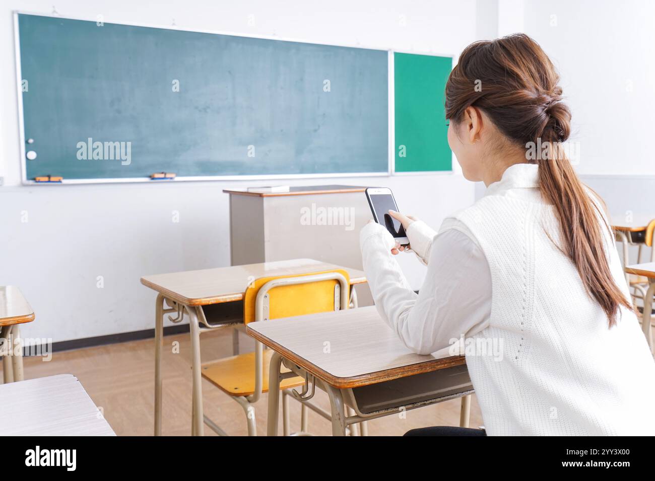 Student using mobile phone in classroom Stock Photo - Alamy