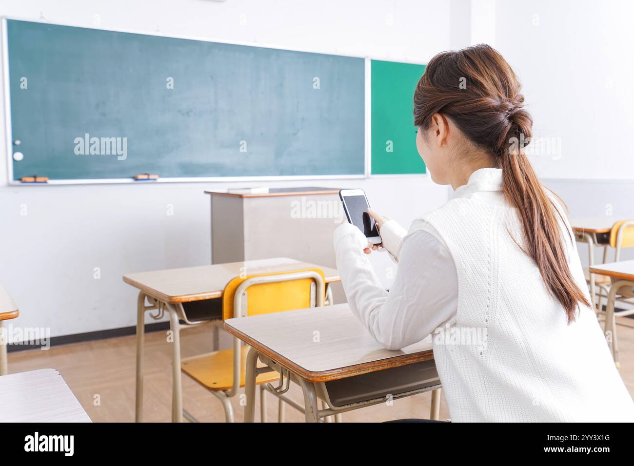 Student using mobile phone in classroom Stock Photo - Alamy