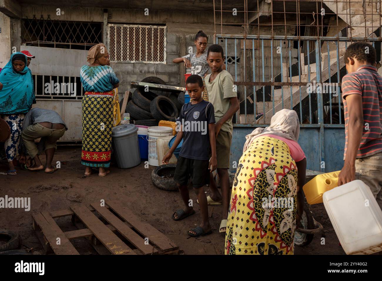 People get water from a well in the lower part of the Kaweni slum where ...