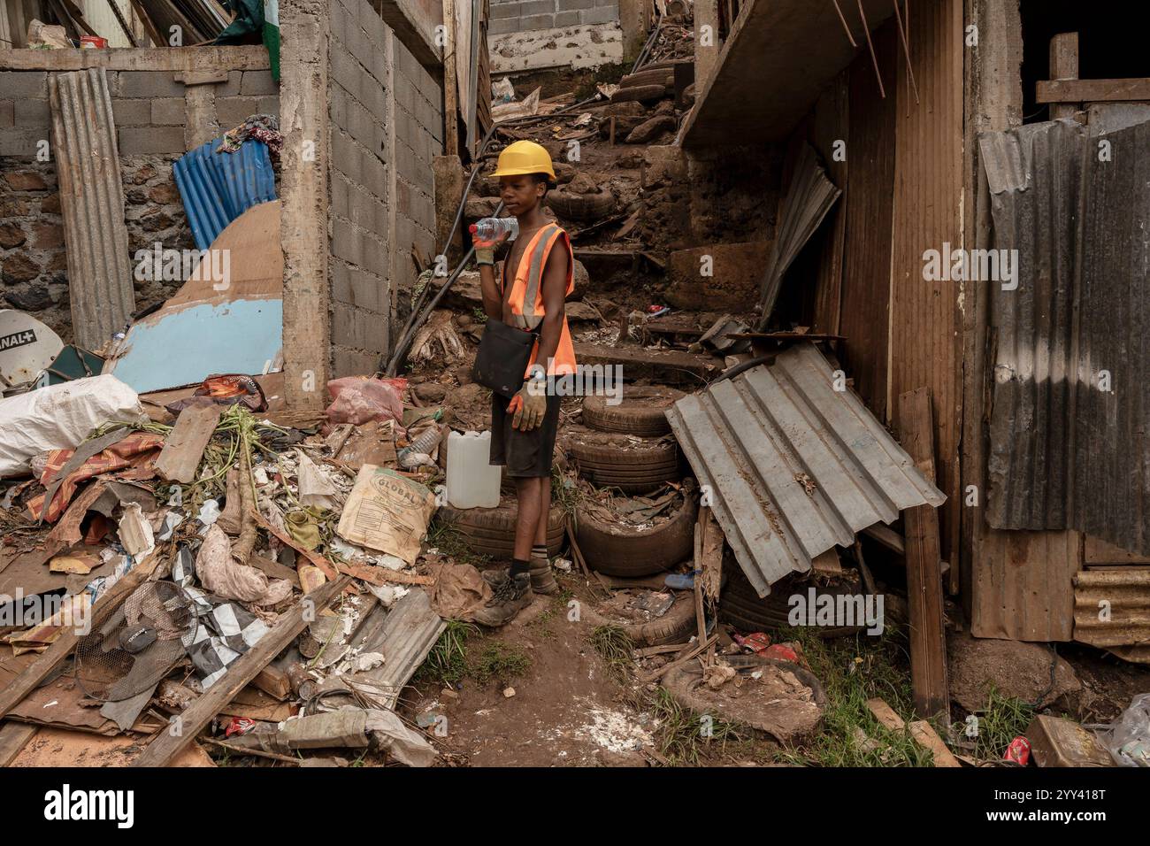 A boy stands amidst debris in the Kaweni slum on the outskirts of ...
