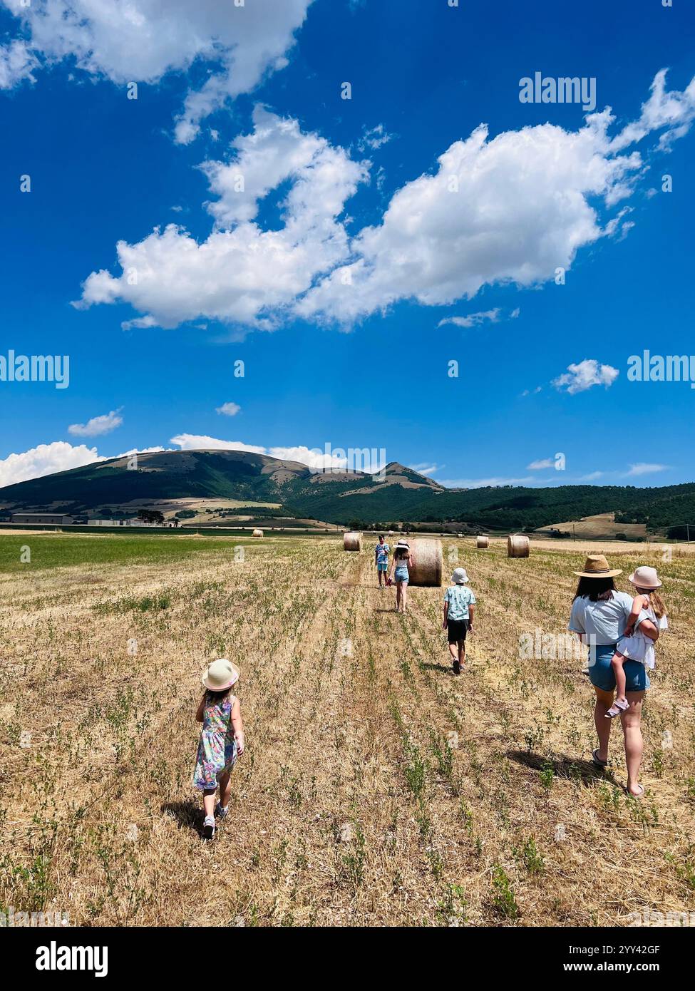 Happy children walk across field hi-res stock photography and images ...