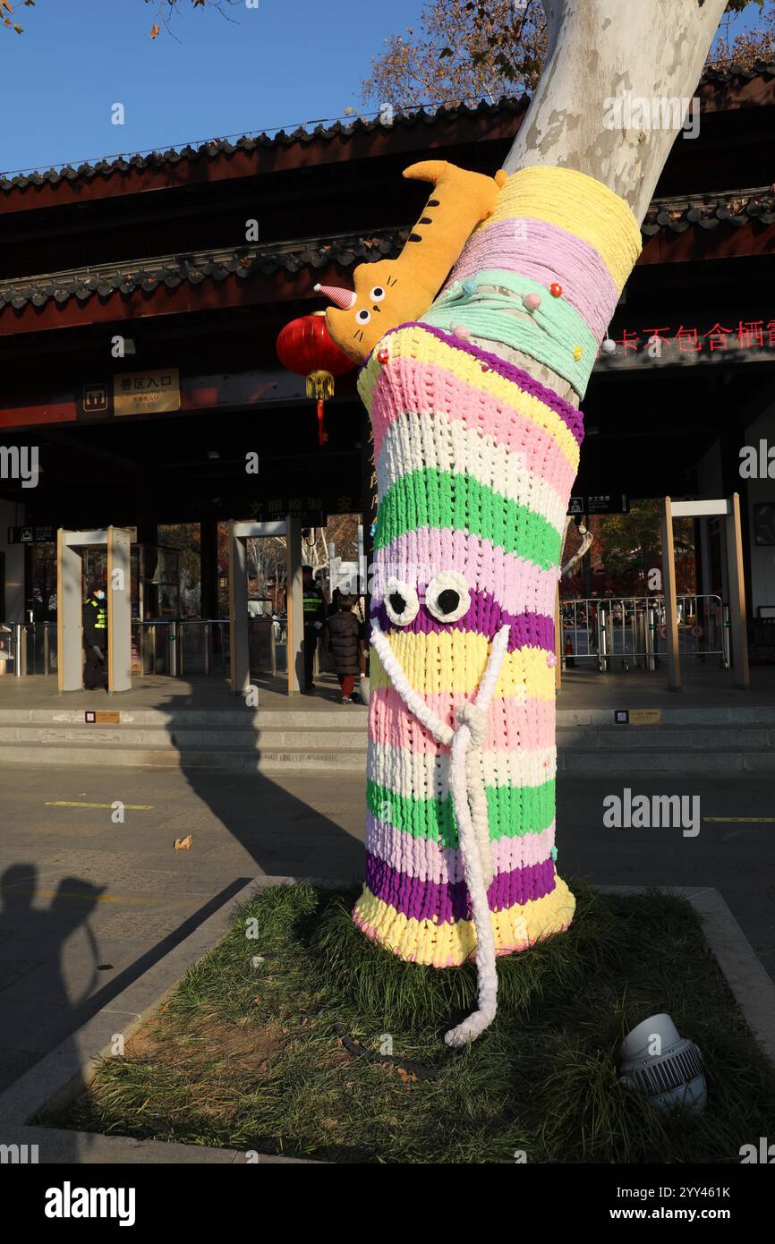 Trees on the street are put on brightly colored "sweaters" for winter ...