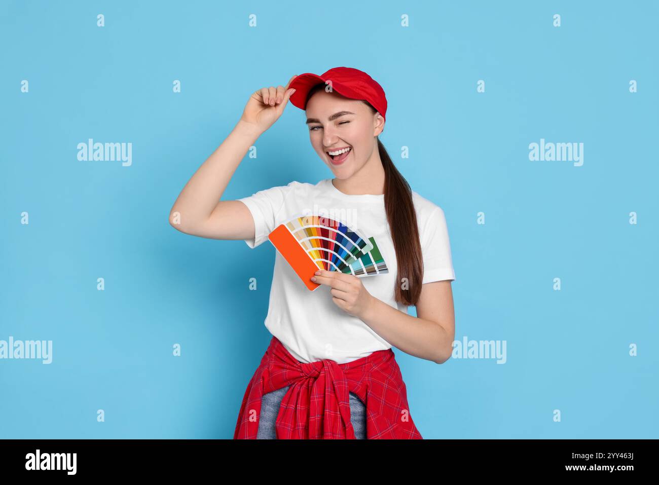Portrait of young decorator with color palettes on light blue ...