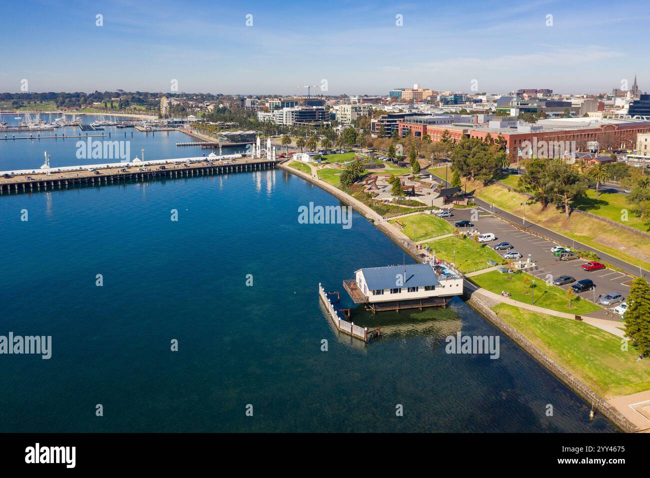 Aerial view of a city waterfront with piers and coastal reserve at ...