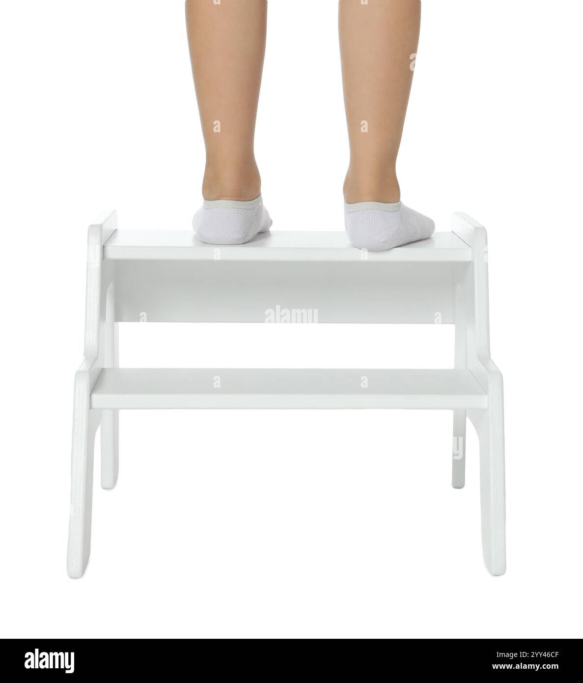 Little girl standing on step stool against white background, closeup ...