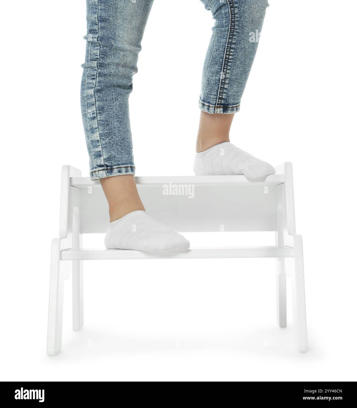 Little girl standing on step stool against white background, closeup ...