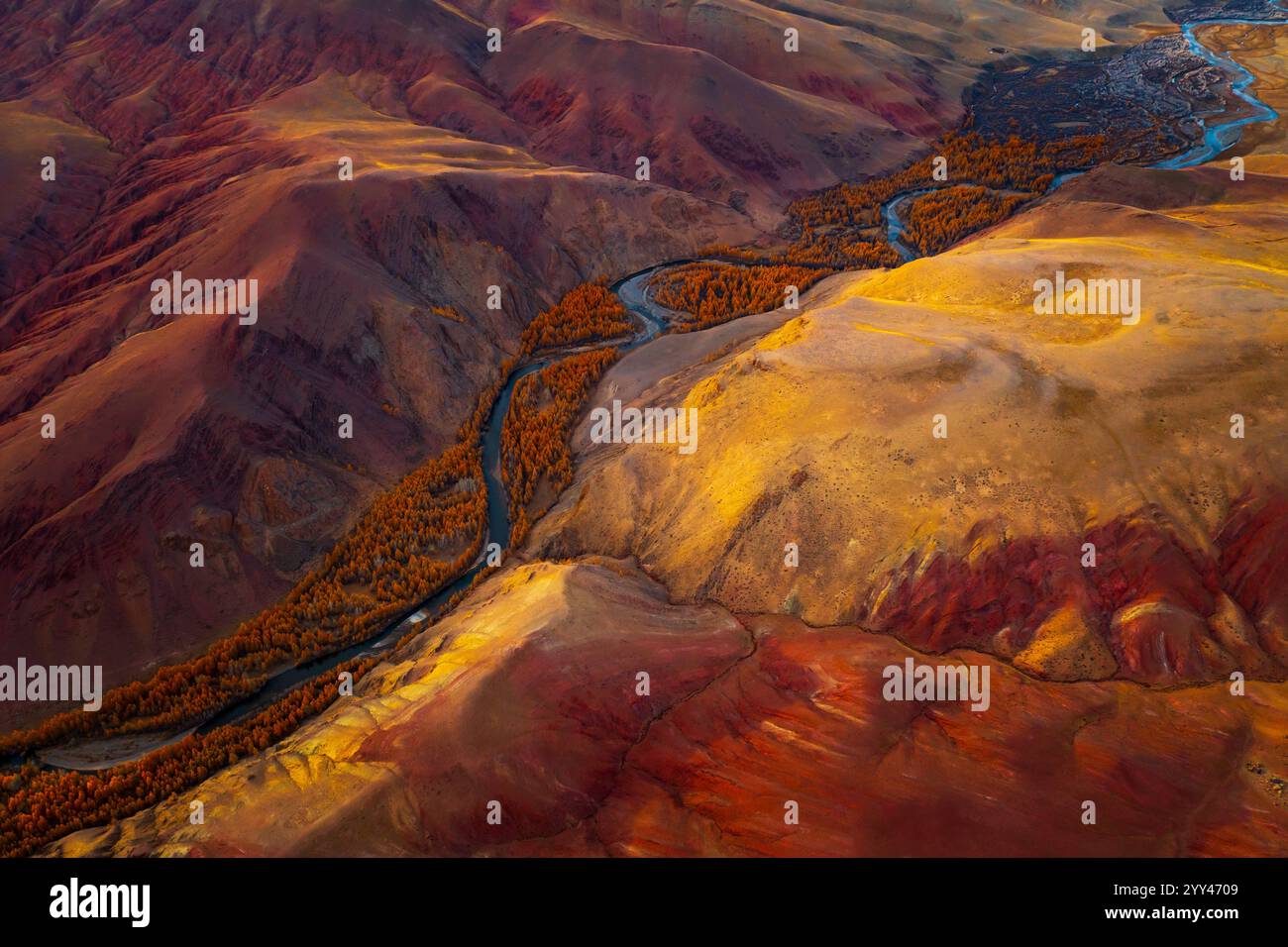 Aerial perspective of a vibrant red and orange rugged valley with a ...