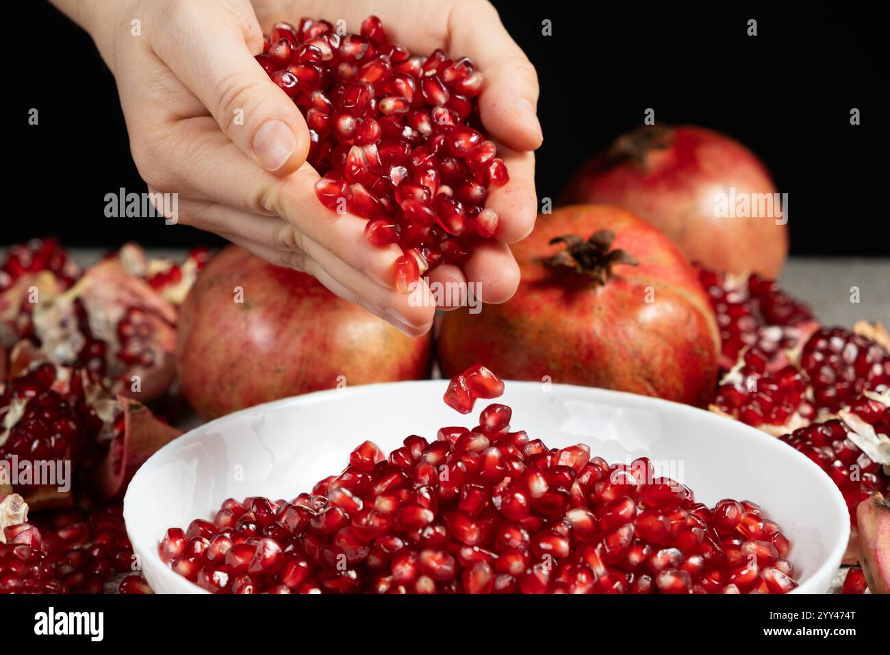 A handful of pomegranate seeds, seeds pouring out of hands Stock Photo ...
