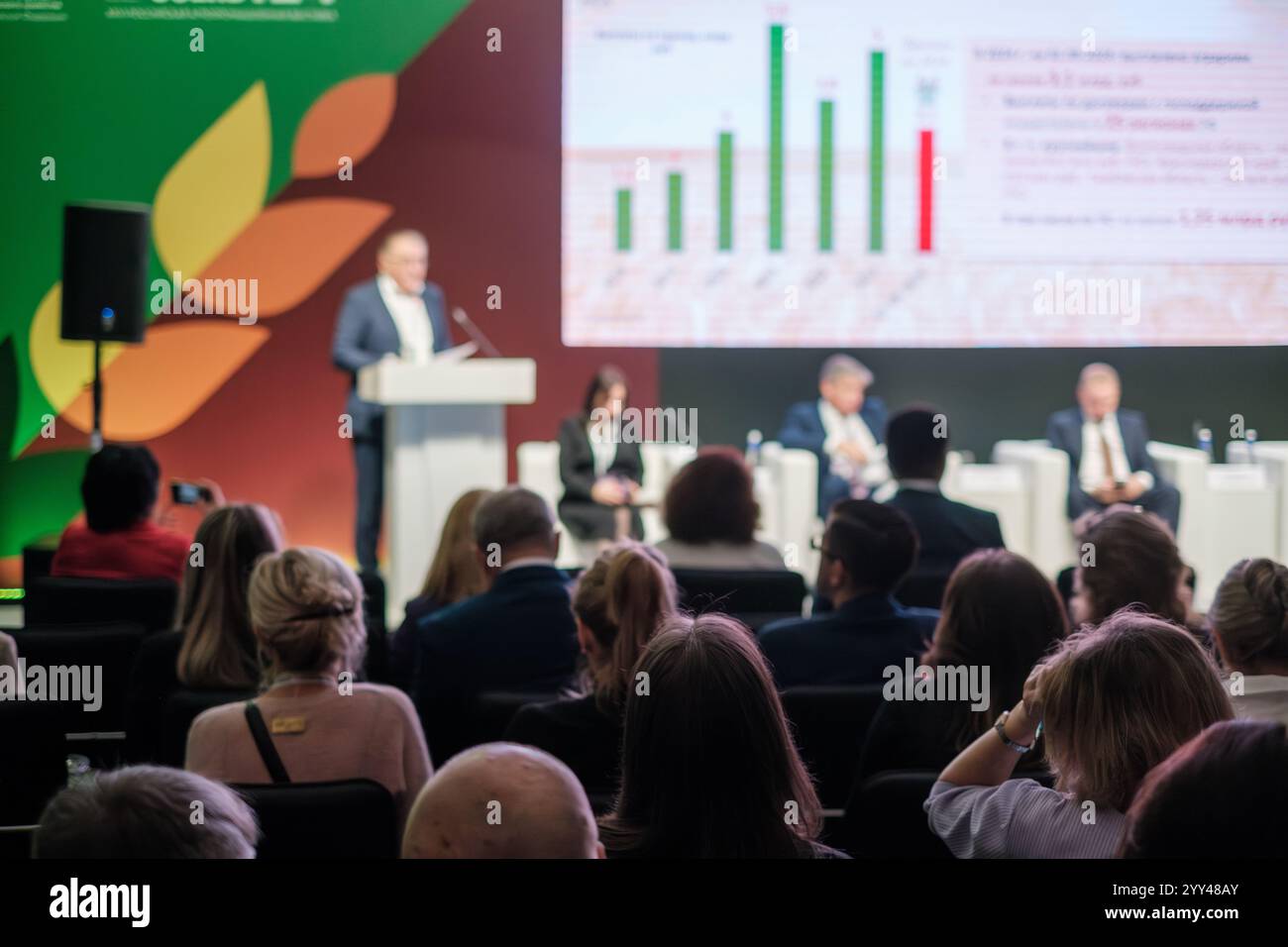 Conference session featuring speaker presenting to engaged audience ...