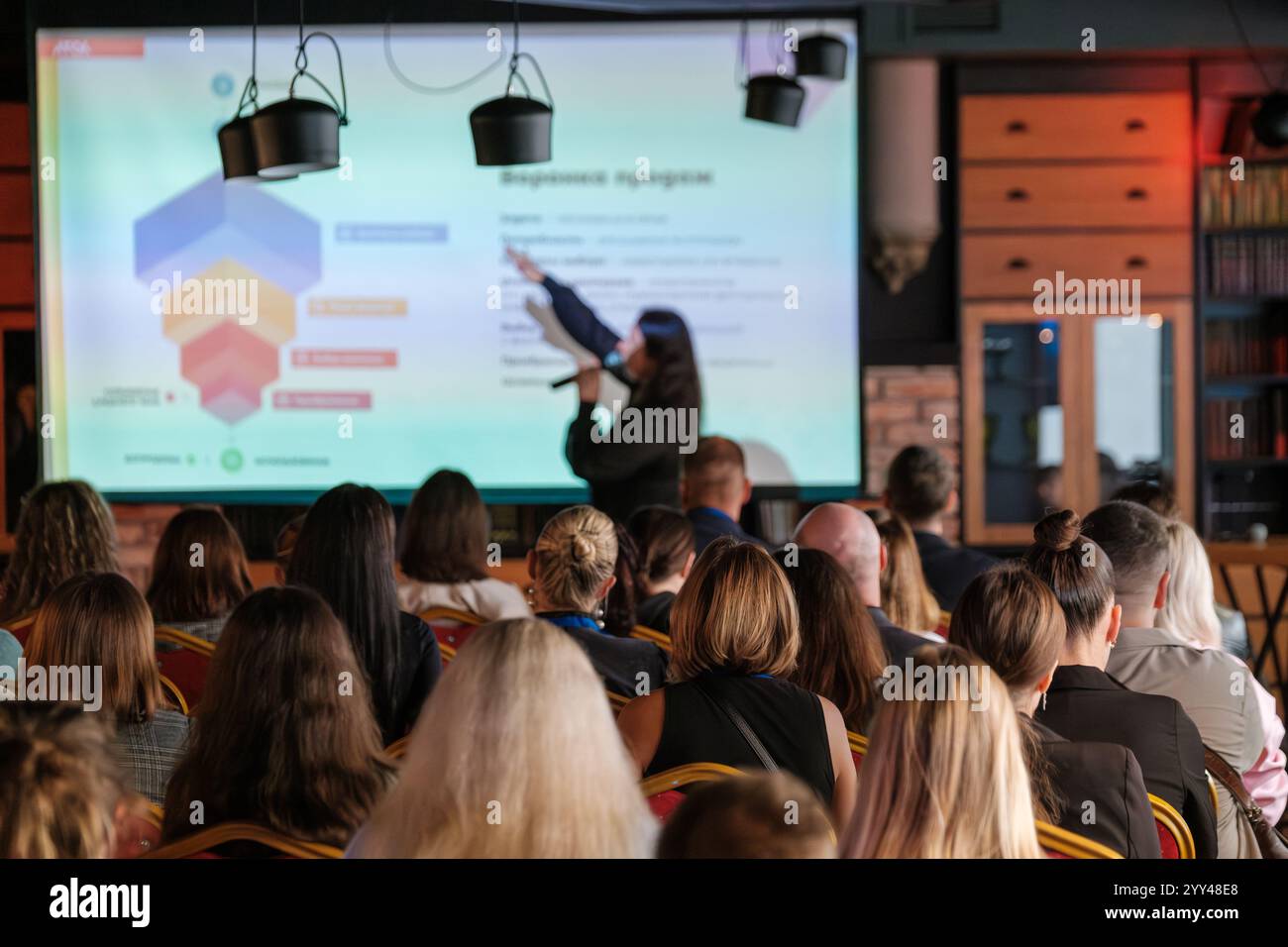Audience seated during a conference presentation while a speaker ...