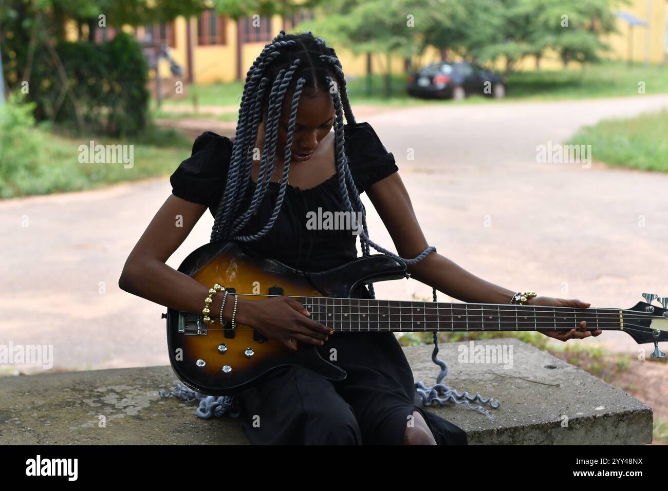 Image of young black african woman playing acoustic guitar outdoor ...