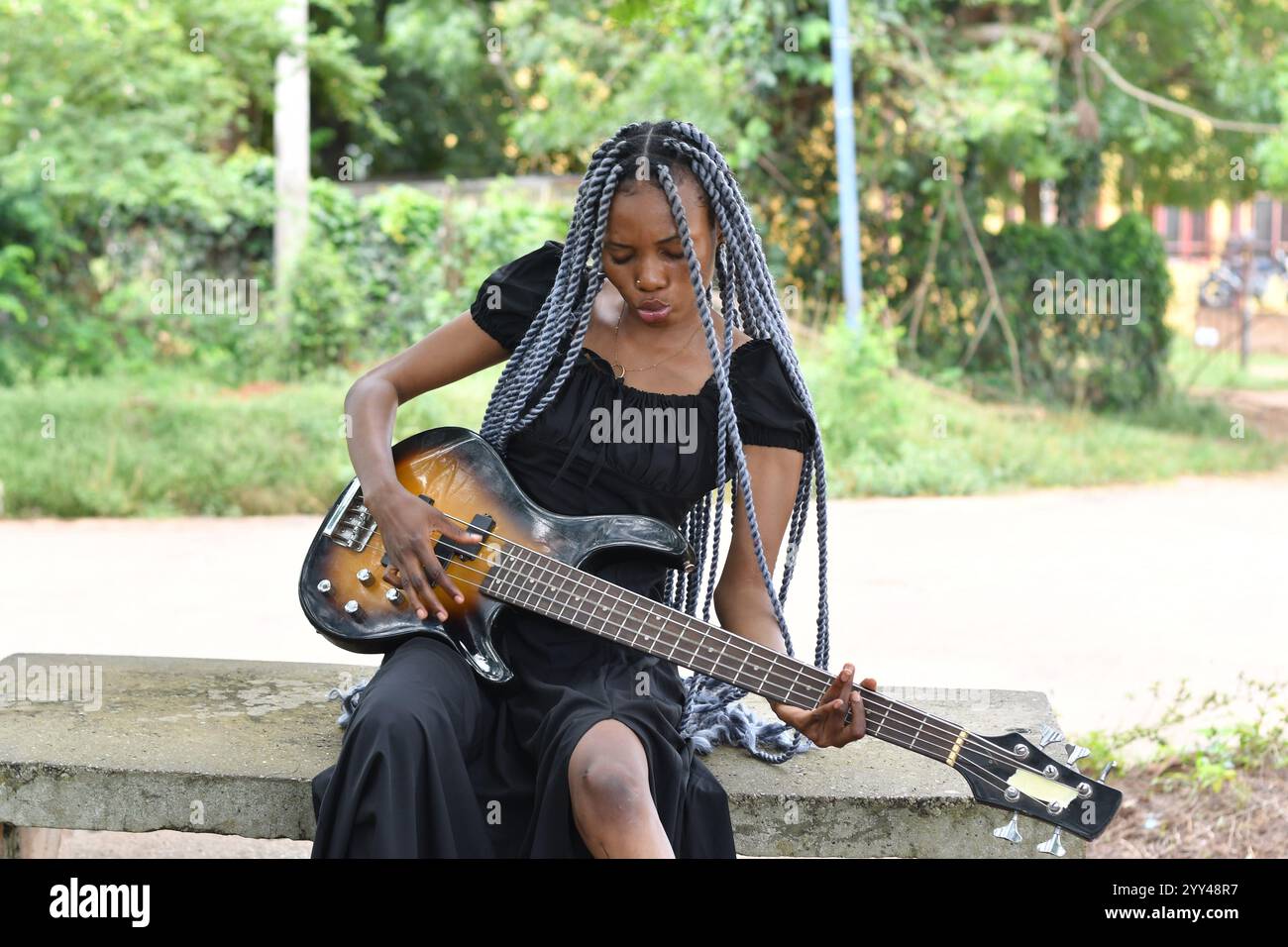 Image of young black african woman playing acoustic guitar outdoor ...
