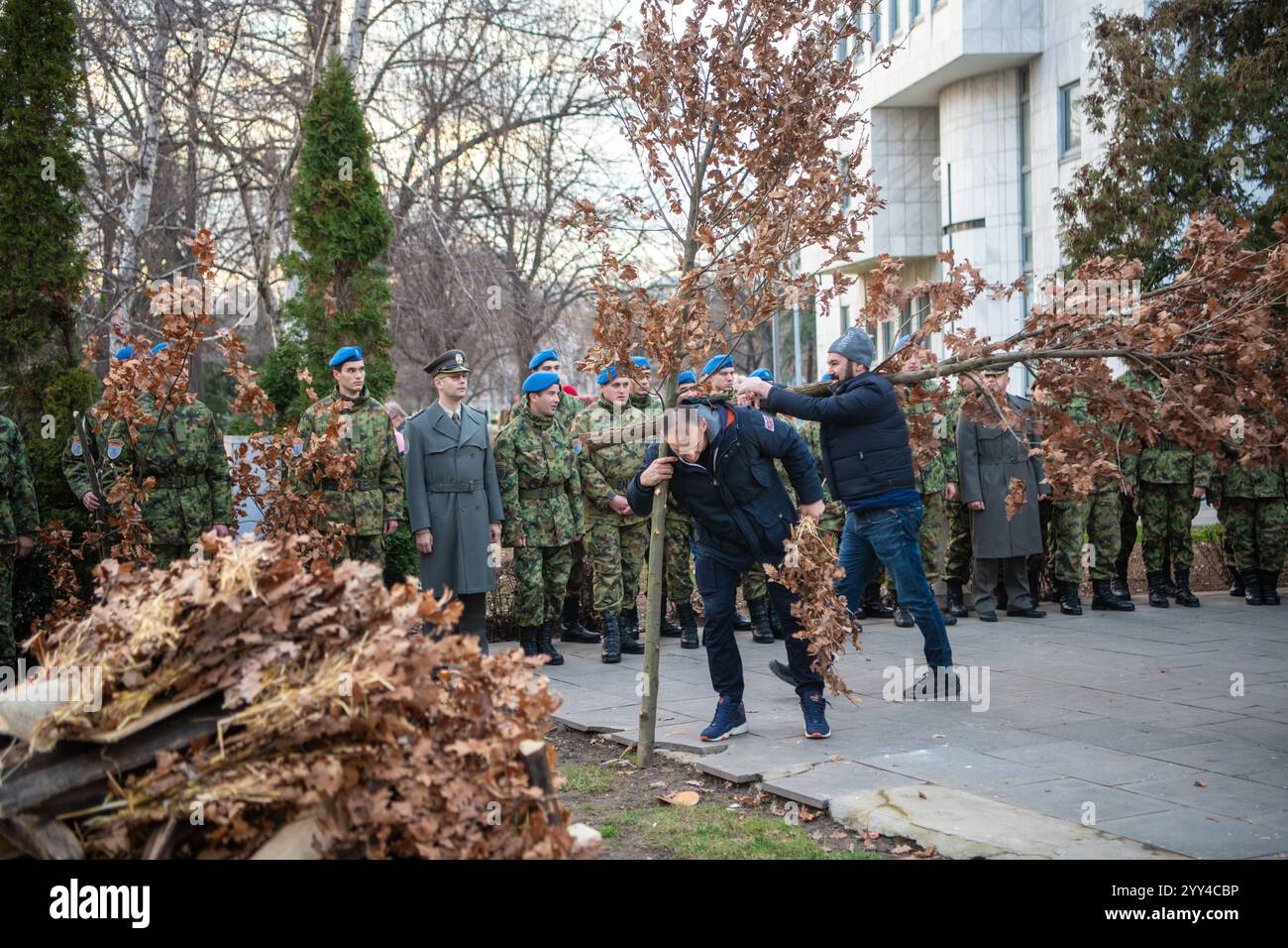 People watch preparation for a ceremonial burning of dried oak branches ...