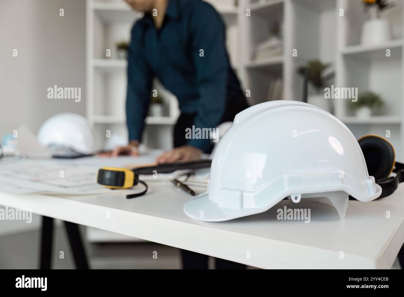 Engineer Reviewing Architectural Blueprints in Modern Office with ...