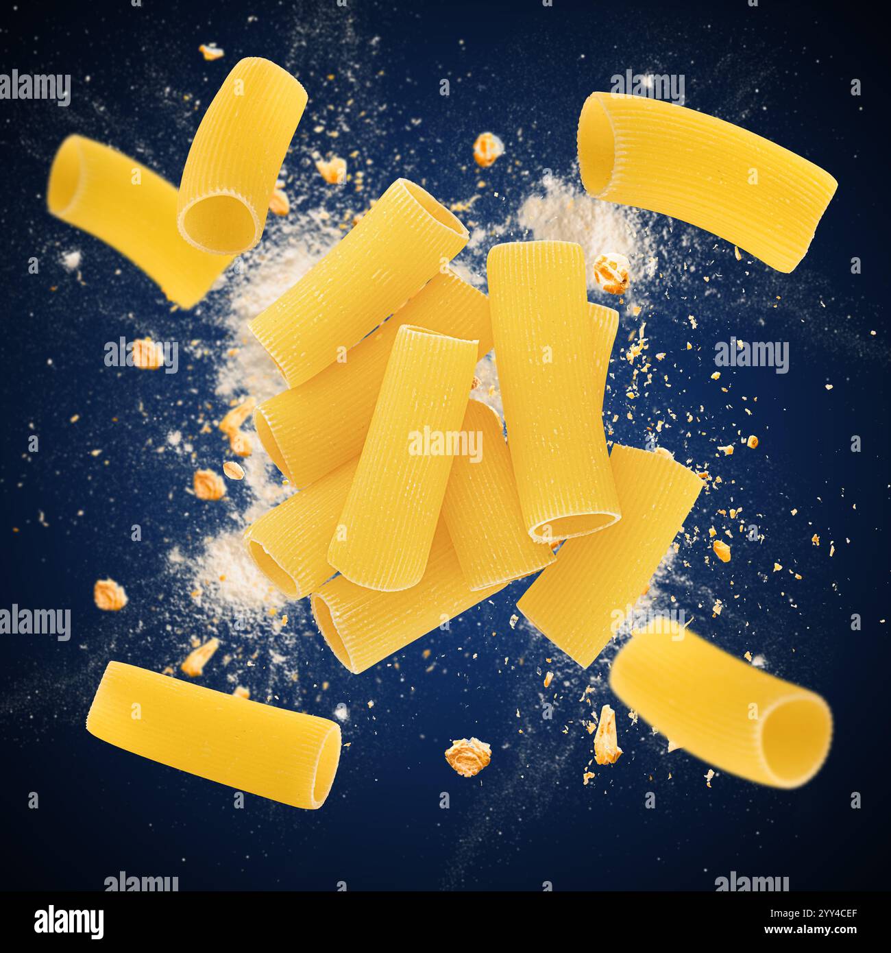 Raw rigatoni pasta exploding on a blue background, creating a dynamic ...